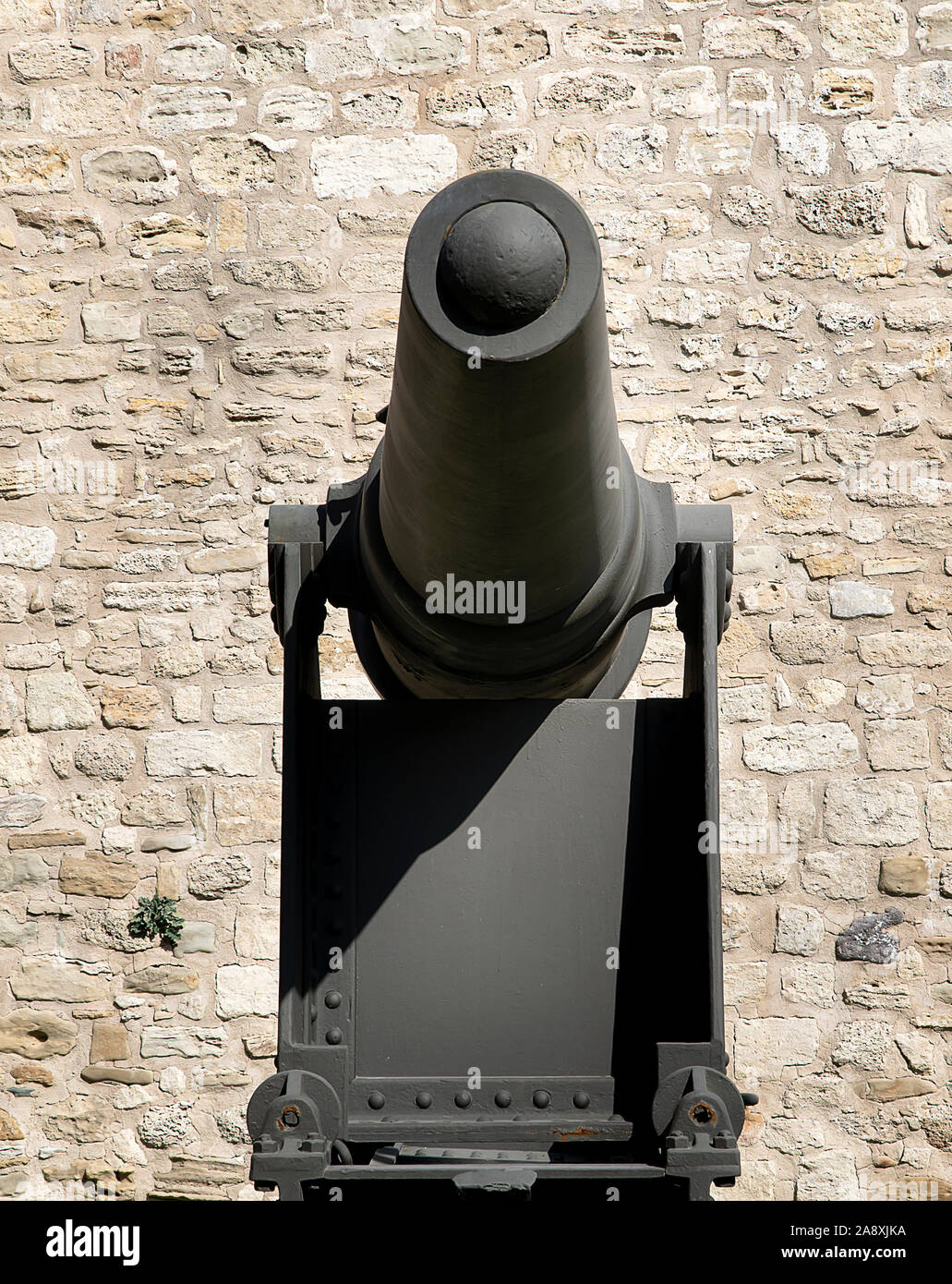 An antique cannon used in the World War I with castle wall on the ...