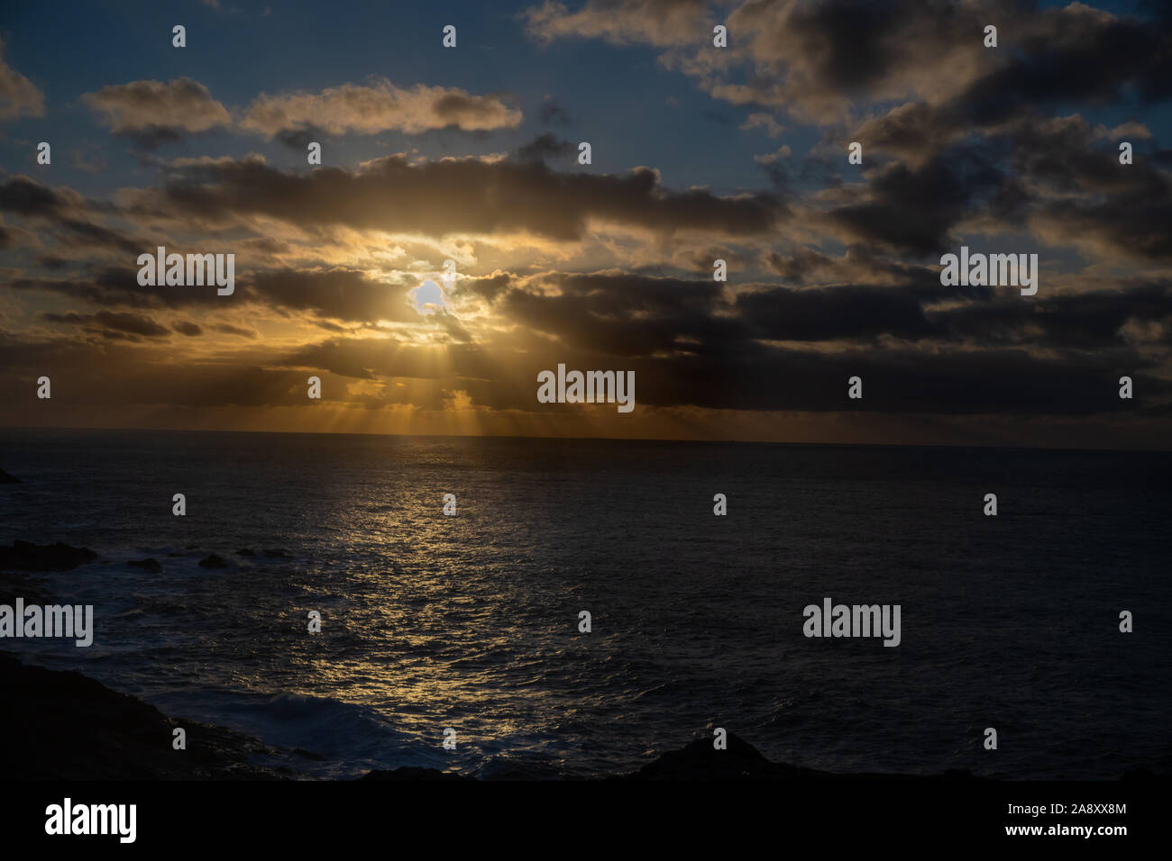 Sun rays behind cloud seascape in Cornwall Stock Photo - Alamy