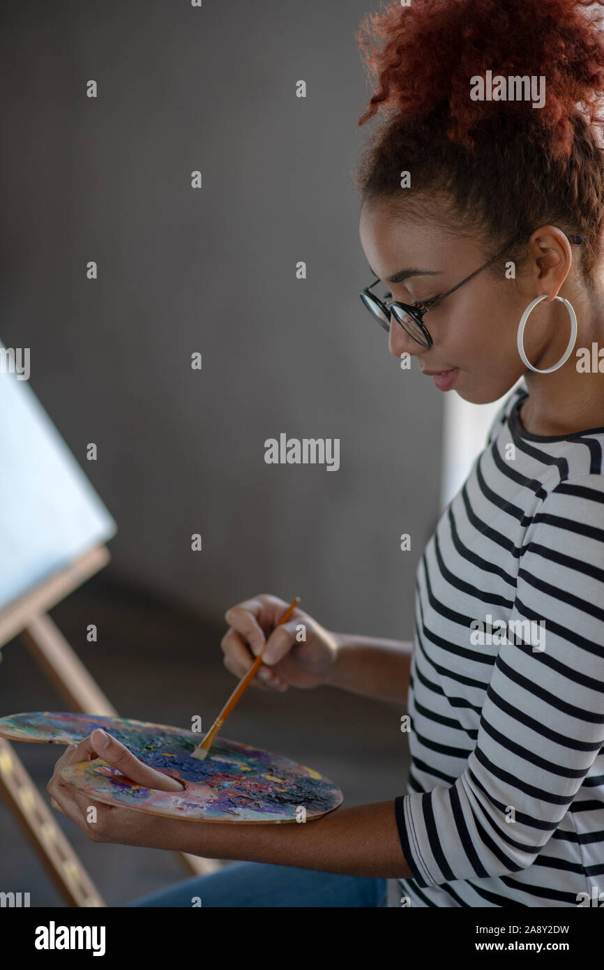 Stylish young artist wearing glasses painting all day Stock Photo - Alamy