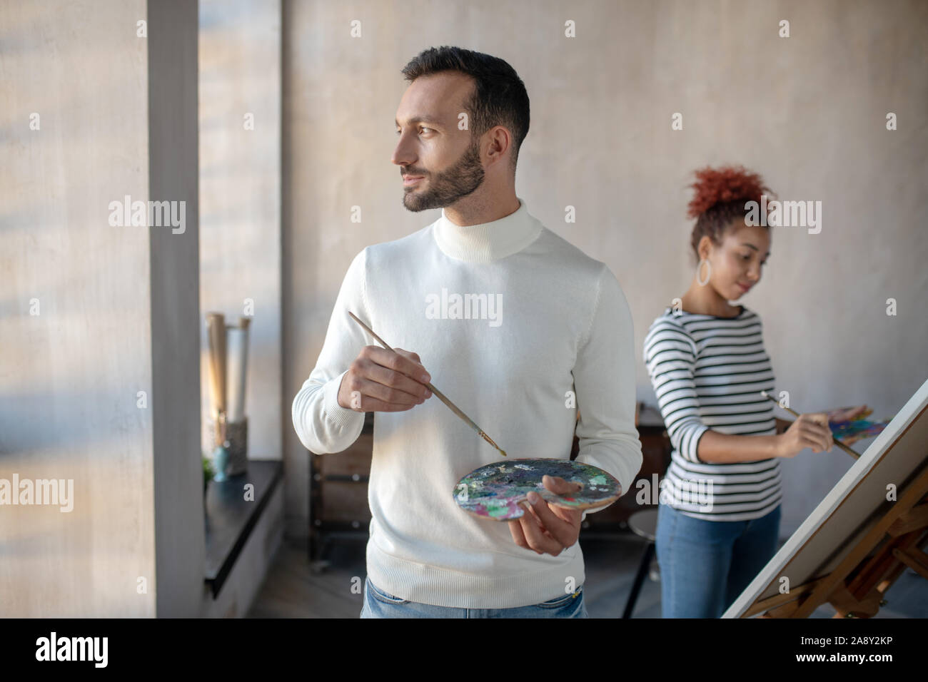 Artist looking into window while painting with girlfriend Stock Photo ...