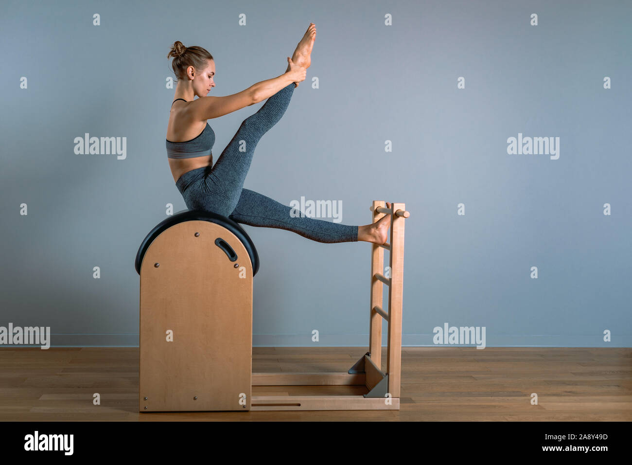 Beautiful positive blond woman is being prepared performing pilates ...