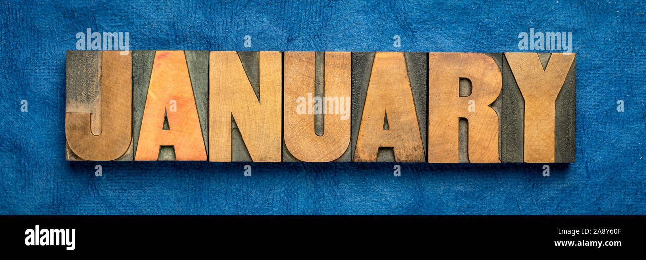 January banner - word in vintage letterpress wood type against dark ...