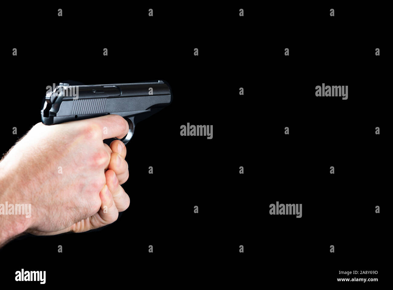 A man with a gun in his hand on a black background. Killer with a gun ...