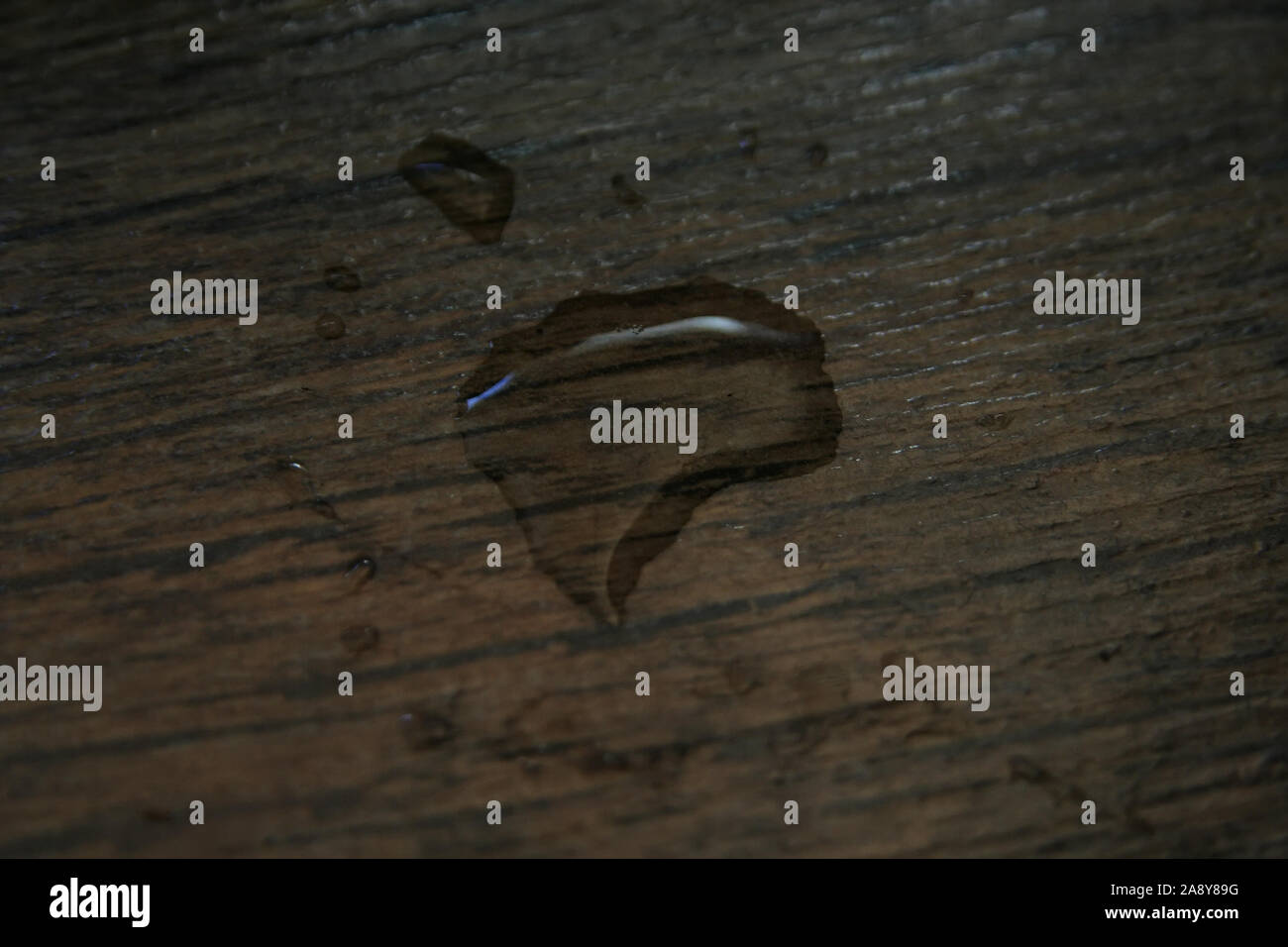 Water drop on a floor. Drop on a wooden floor Stock Photo - Alamy