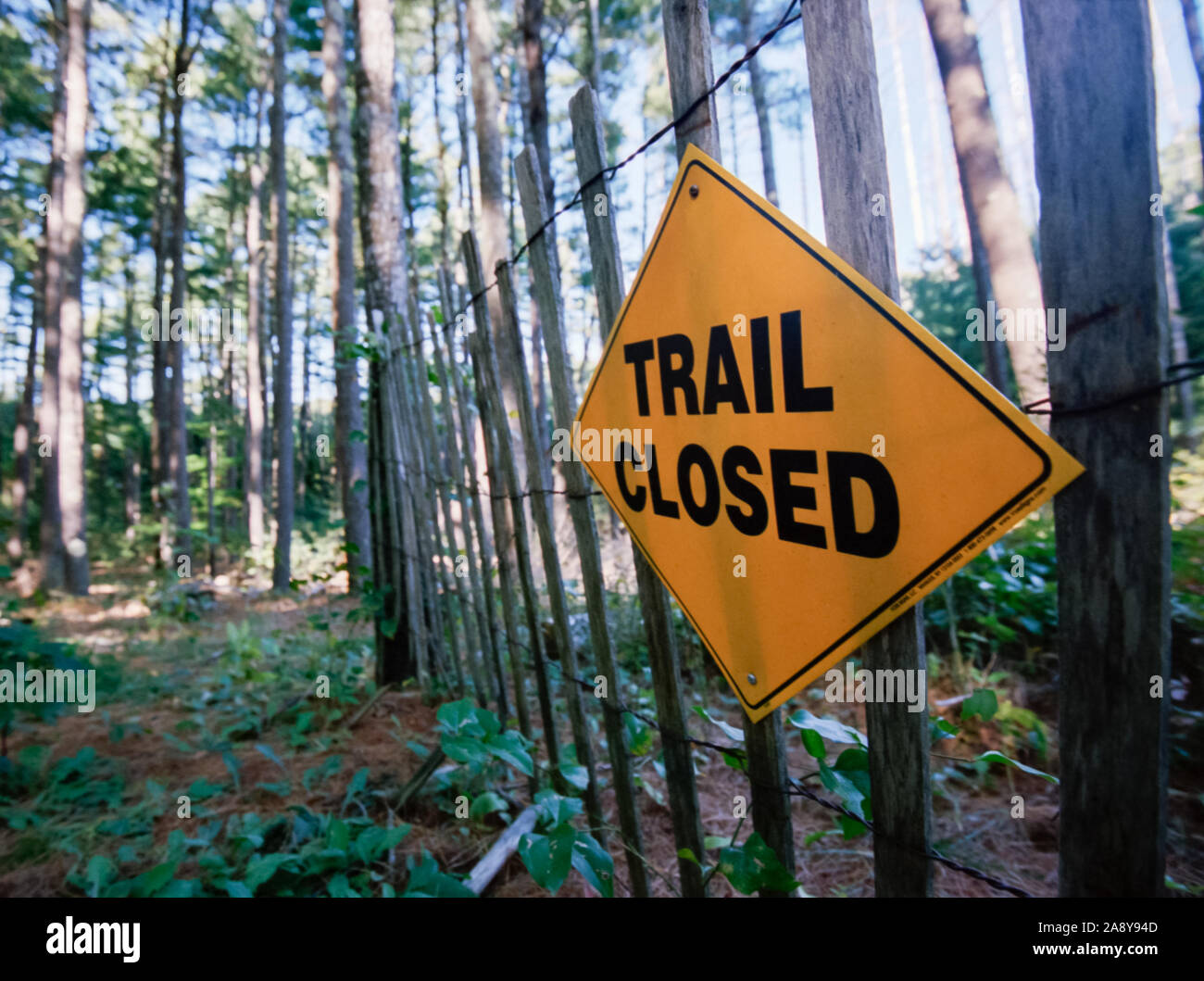 A Yellow Trail Closed Sign and a Fence Stock Photo - Alamy