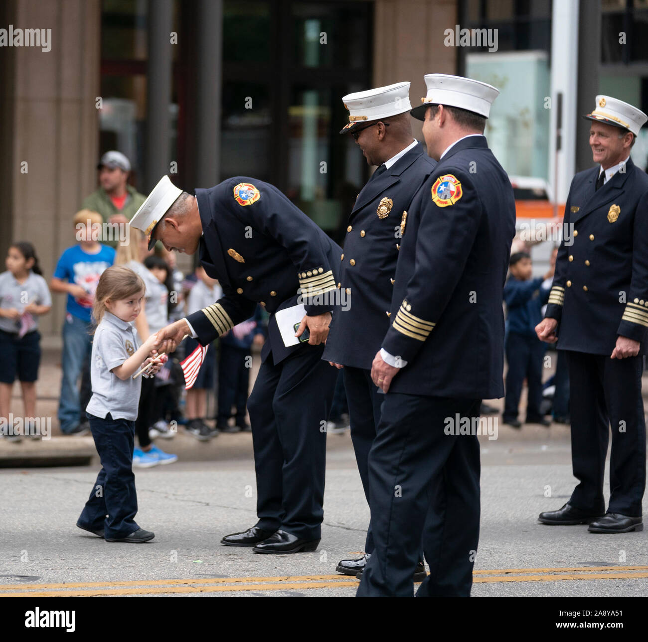 A young parade watcher greets an Austin firefighter with a handshake ...