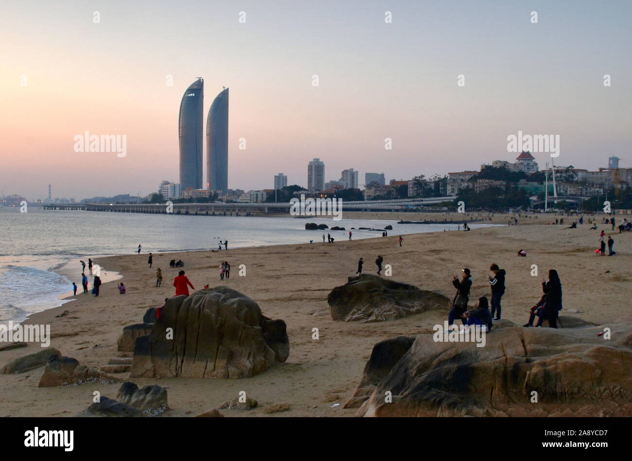 Xiamen modern city skyline from Baicheng beach by Taiwan strait at dusk ...