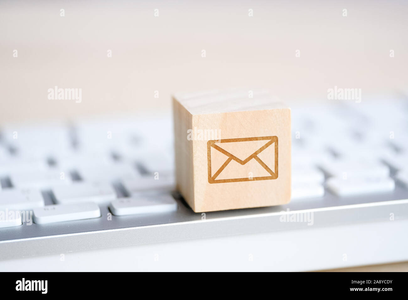 Wooden cube with the image of a mail symbol envelope in his hand ...
