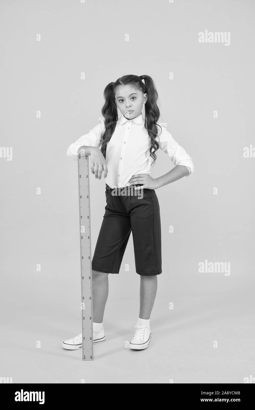 Where student comes first. Serious small student holding wooden ruler ...