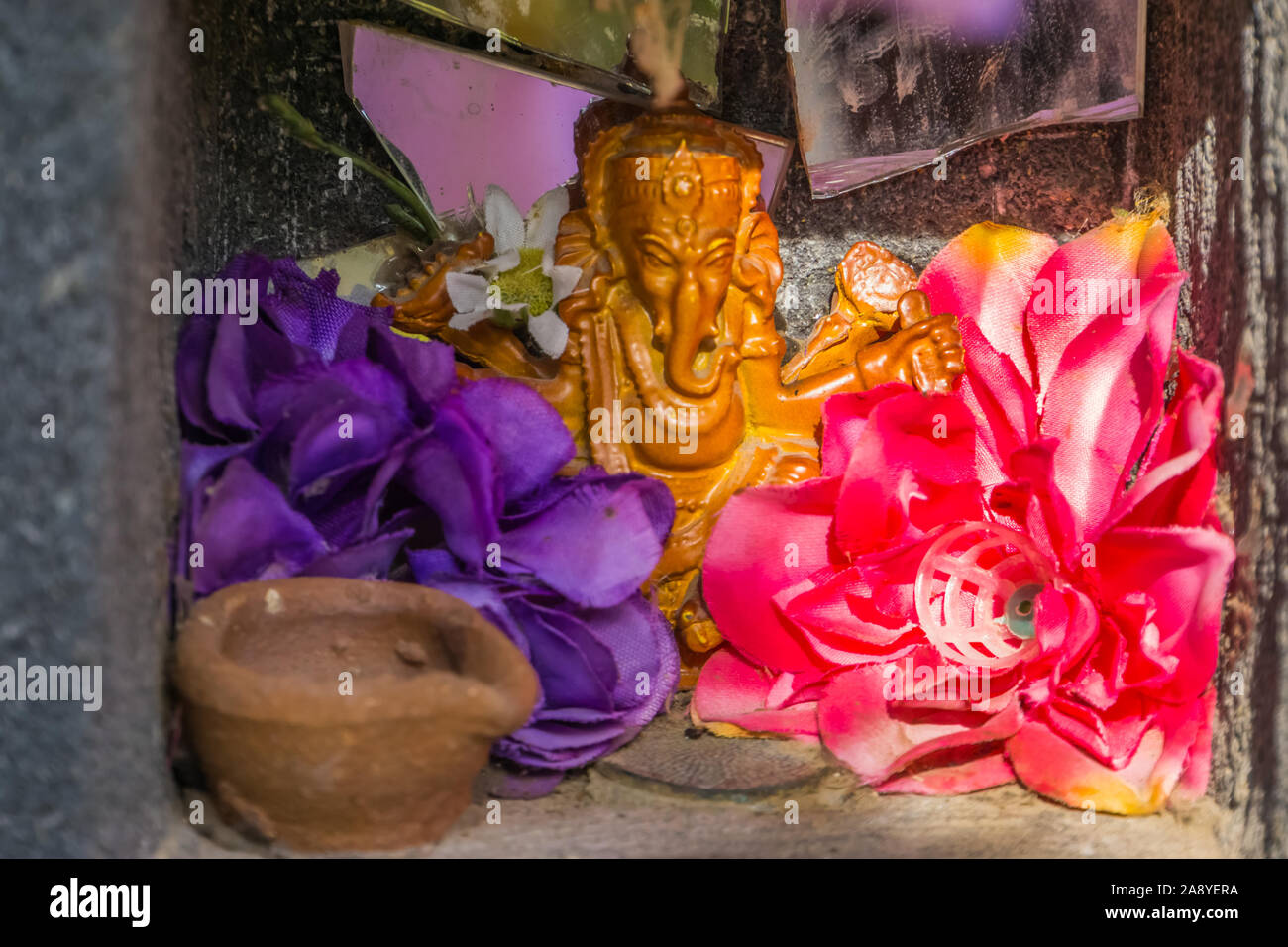 beautiful small Indian altar with flowers and a Ganesha sculpture ...