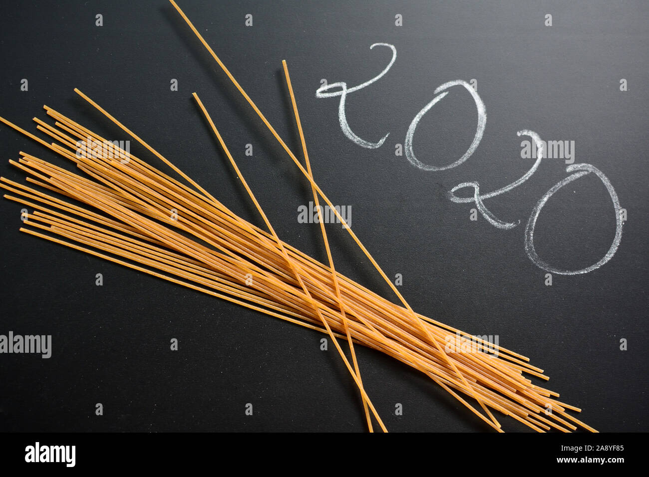 Spaghetti unboiled on black background with number 2020 from above ...