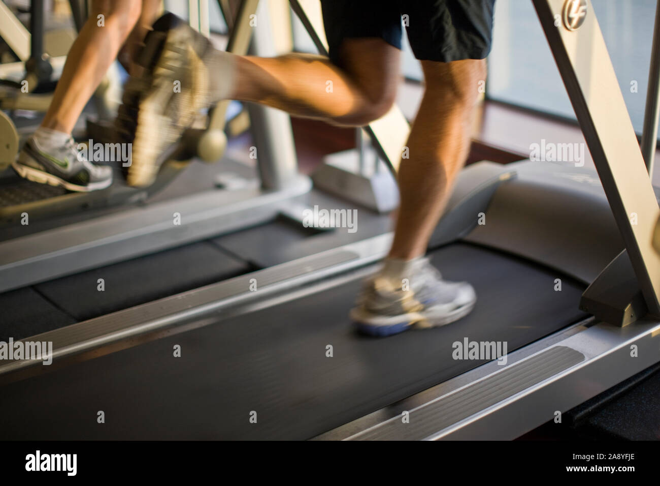 Legs running on a treadmill inside a gym Stock Photo - Alamy