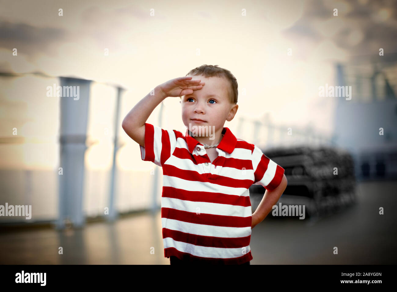 Young boy saluting while standing on the deck of a boat Stock Photo - Alamy