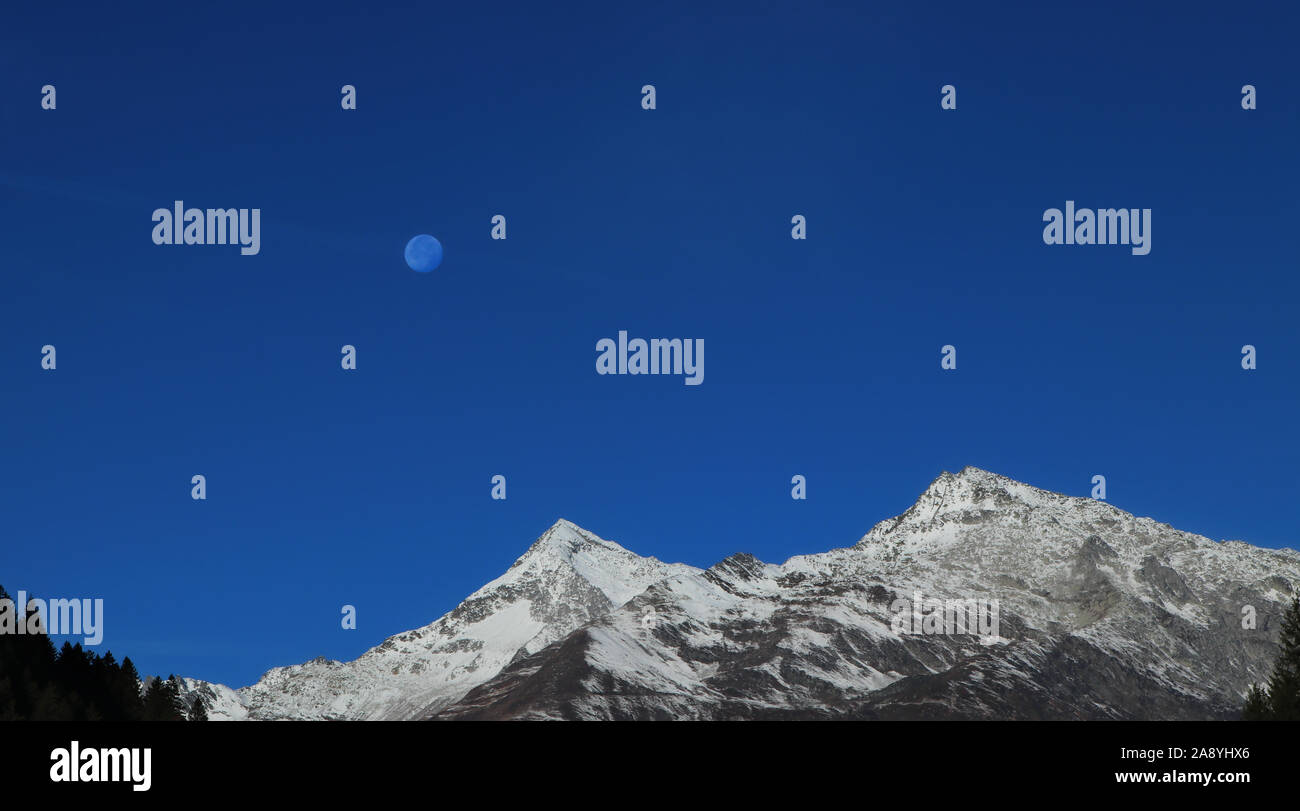 mountains in switzerland with moon shining Stock Photo - Alamy