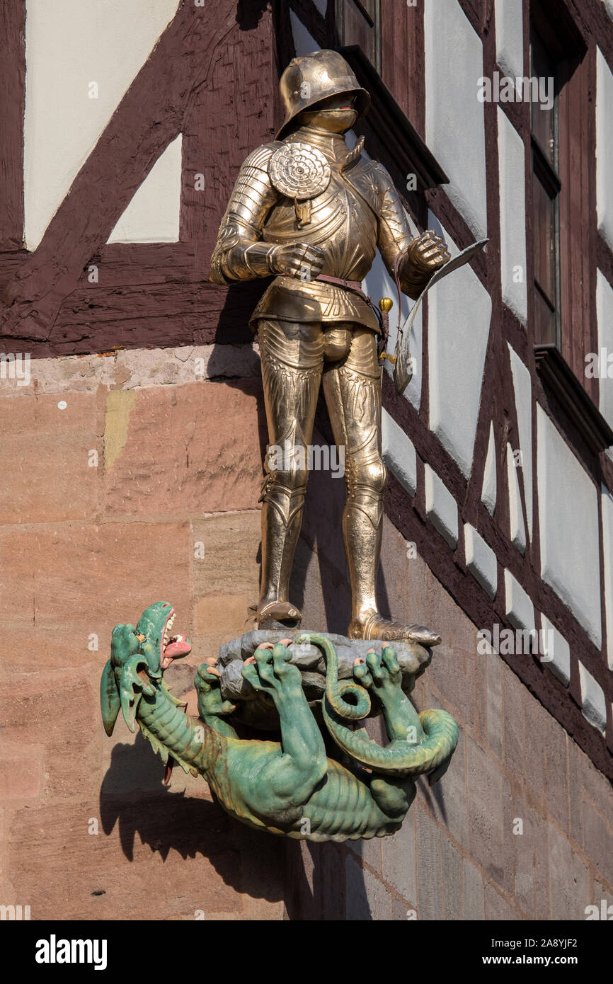 A sculpture of a soldier in a suit of armour with a dragon at his feet ...