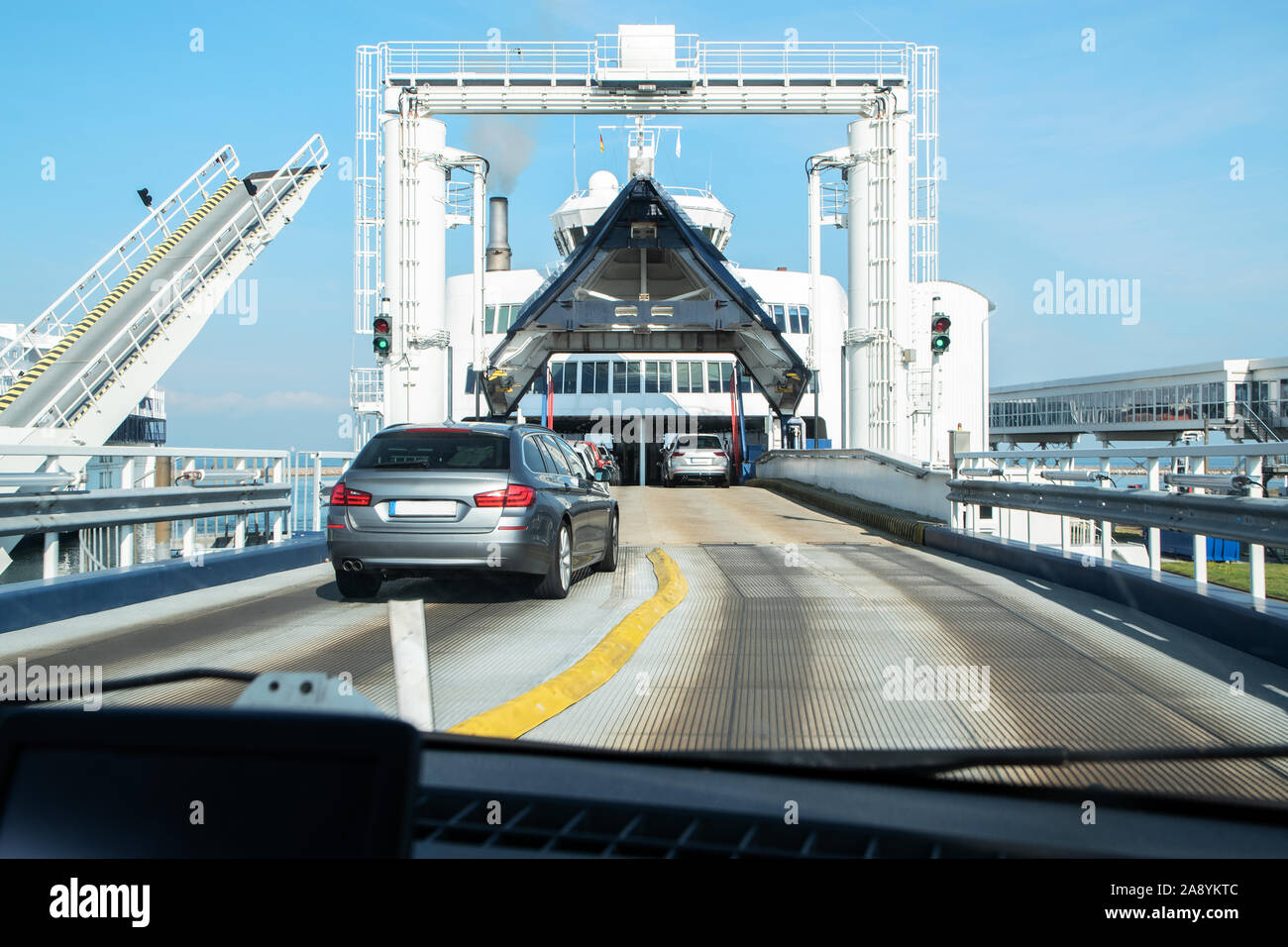 Cars on the drive up to a big ferry boat in the port for a journey over ...