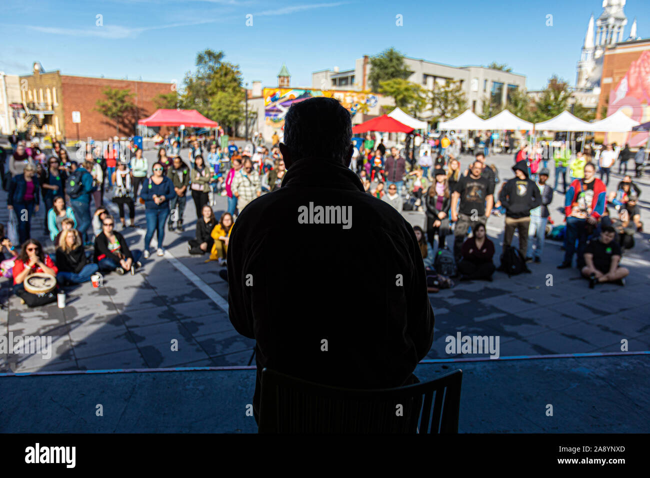 Silhouette of man talking to crowd at open public space. People ...