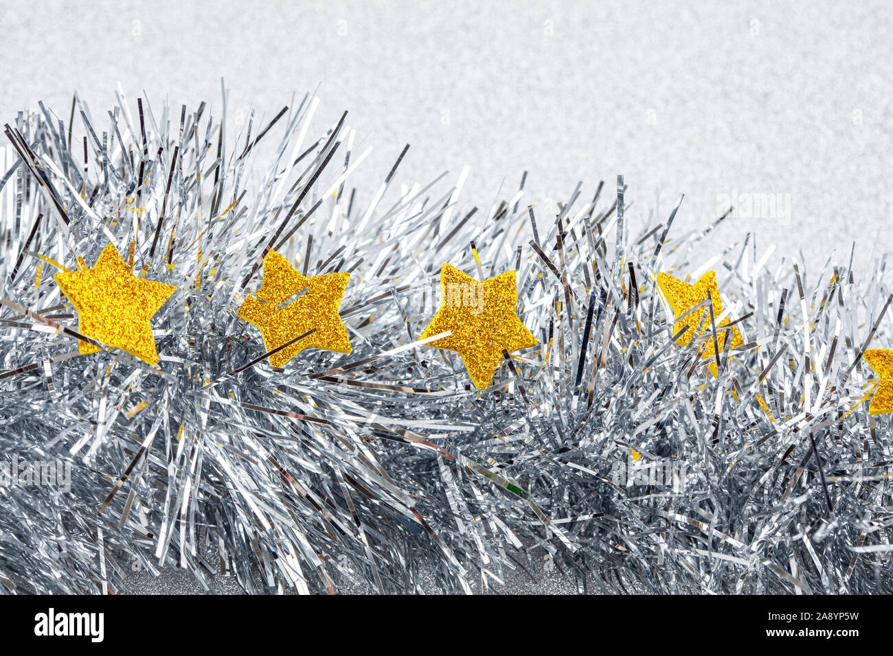 Golden glitter stars with silver tinsel on blurred background ...