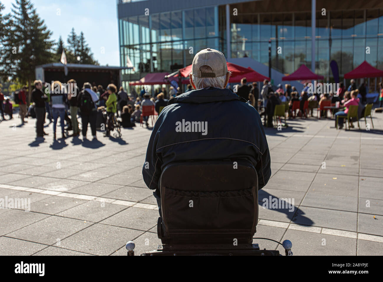Selective focus on old man form the back sitting at open public space ... Selective focus on old man form the back sitting at open public space ...