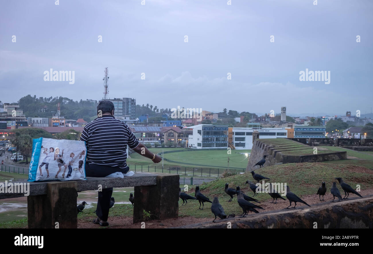 Galle, SRI LANKA- AUG 11 2019: The unspecific man sitting on the wall ...