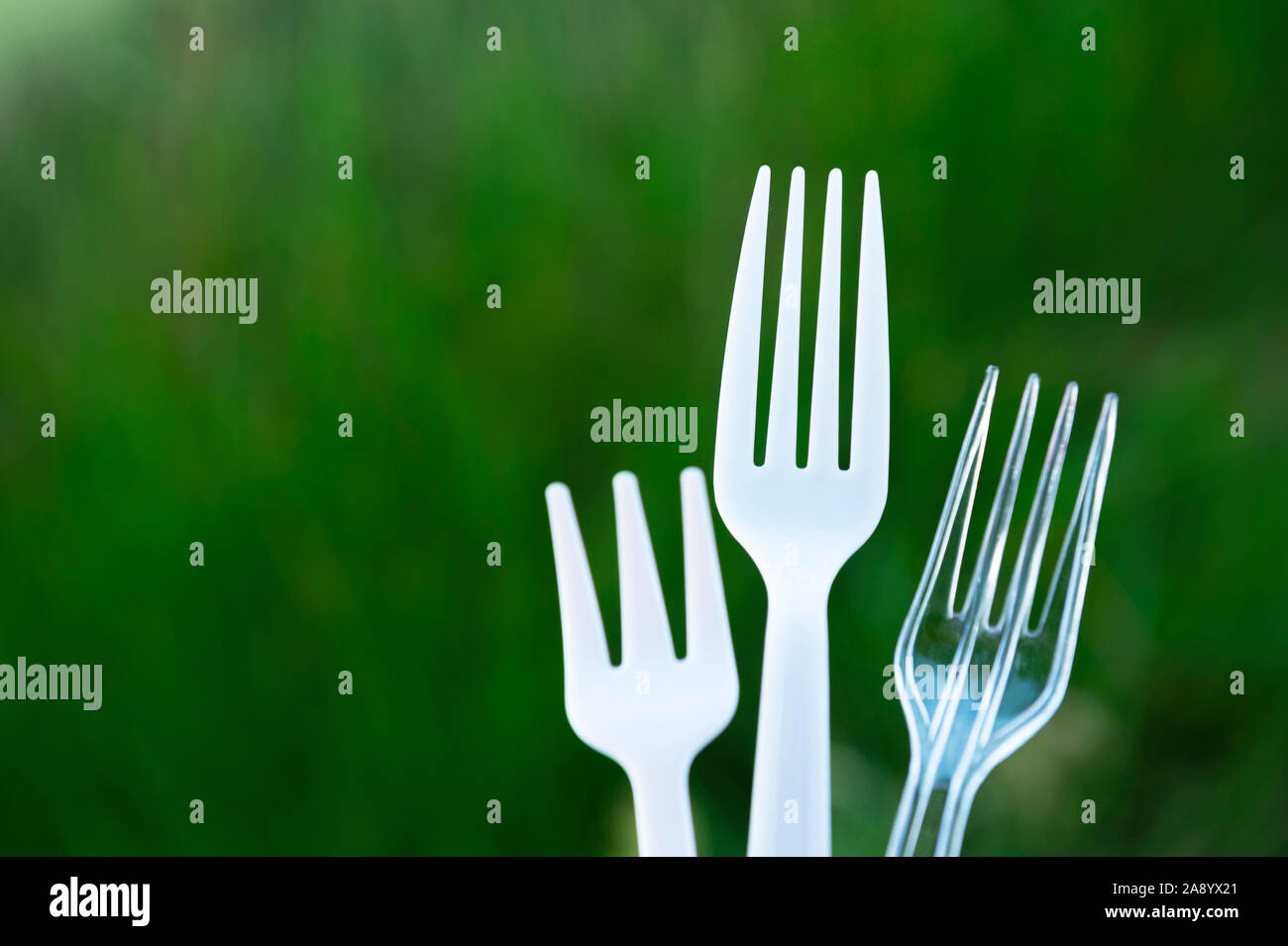 three white disposable white forks in garbage environmental pollution ...