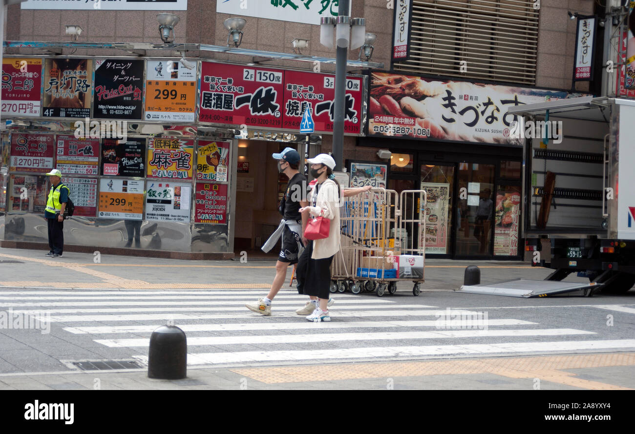 Japanese couple wearing masks, walking in Shinjuku, Tokyo, Japan, Asia ...