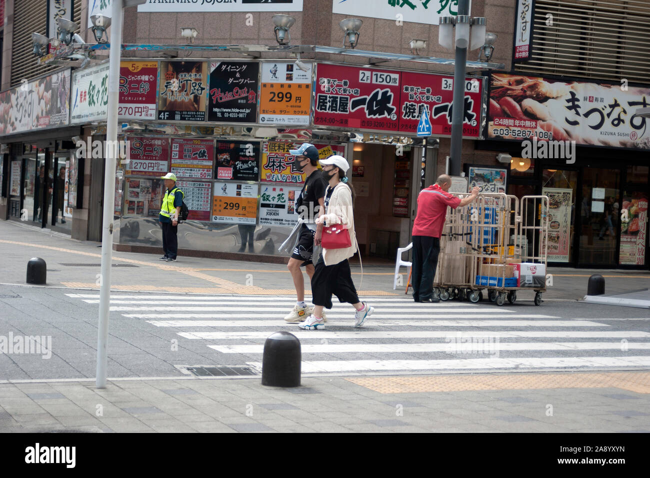 Japanese couple wearing masks, walking in Shinjuku, Tokyo, Japan, Asia ...