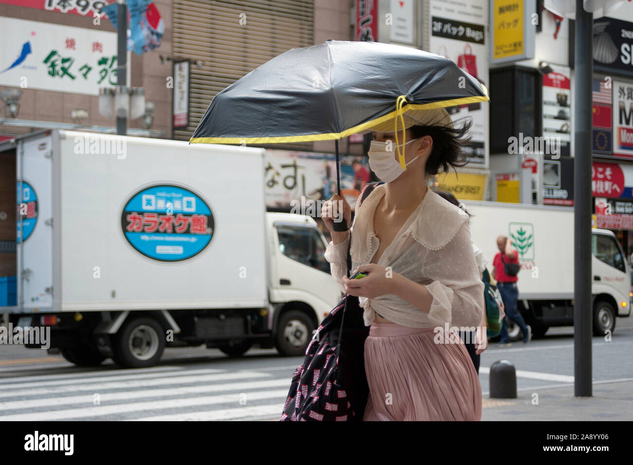 Japanese woman, wearing mask, walking in Shinjuku, Tokyo, Japan, Asia ...
