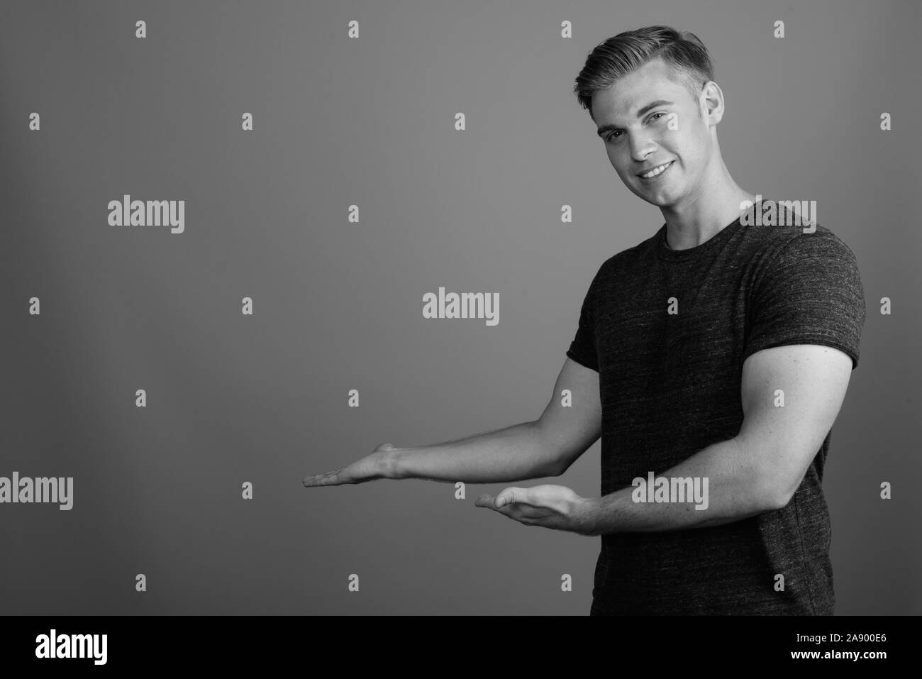 Portrait of young handsome man against gray background in black and ...