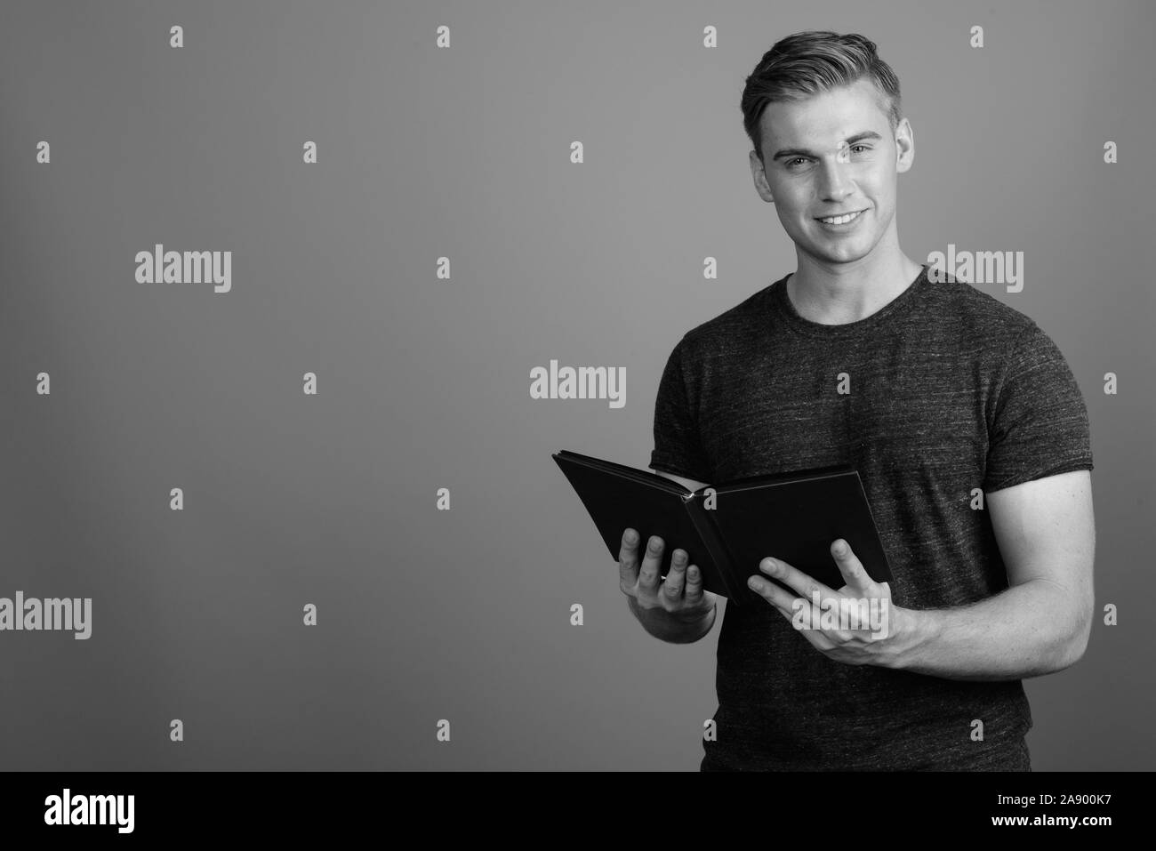 Portrait of young handsome man against gray background in black and ...