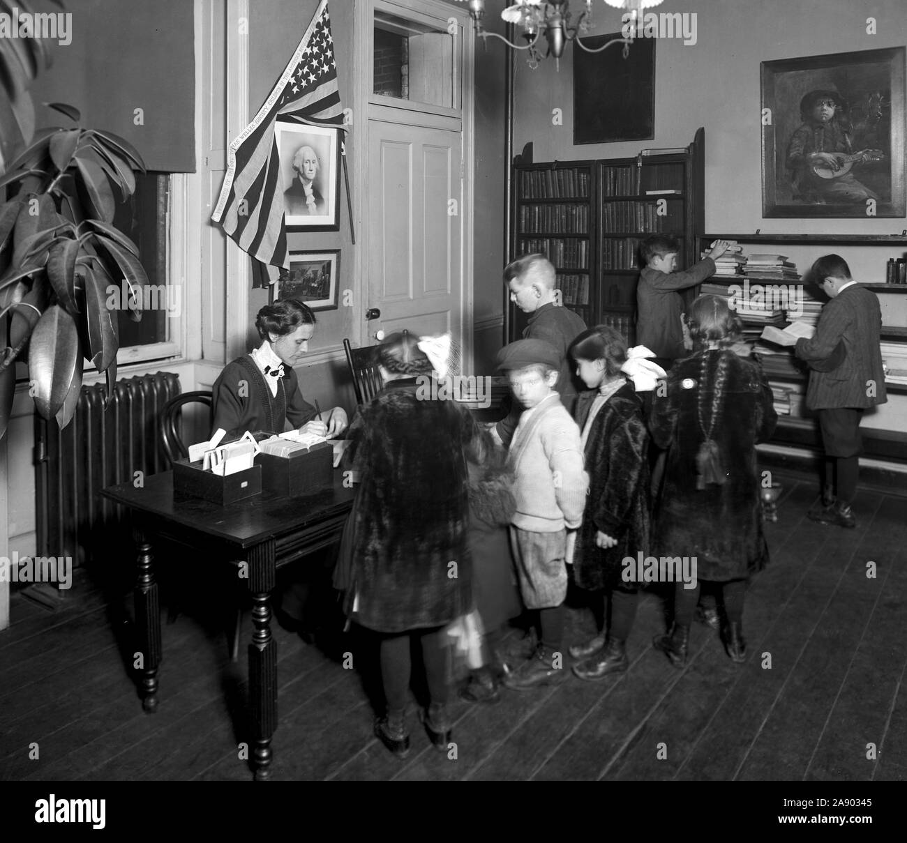 Children and librarian in an early 1900s library Stock Photo - Alamy