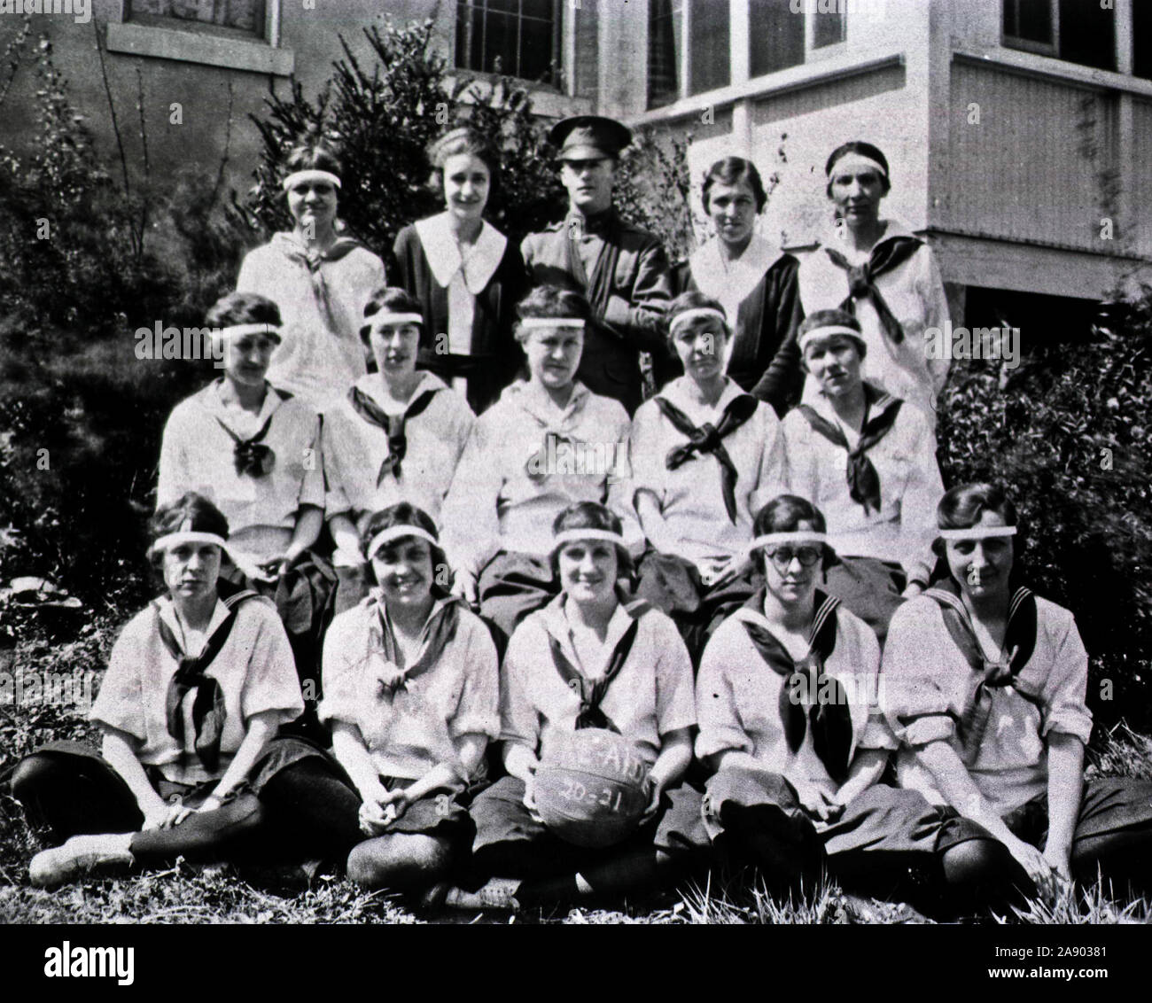 Three rows of women in athletic uniforms pose for a picture in front of ...