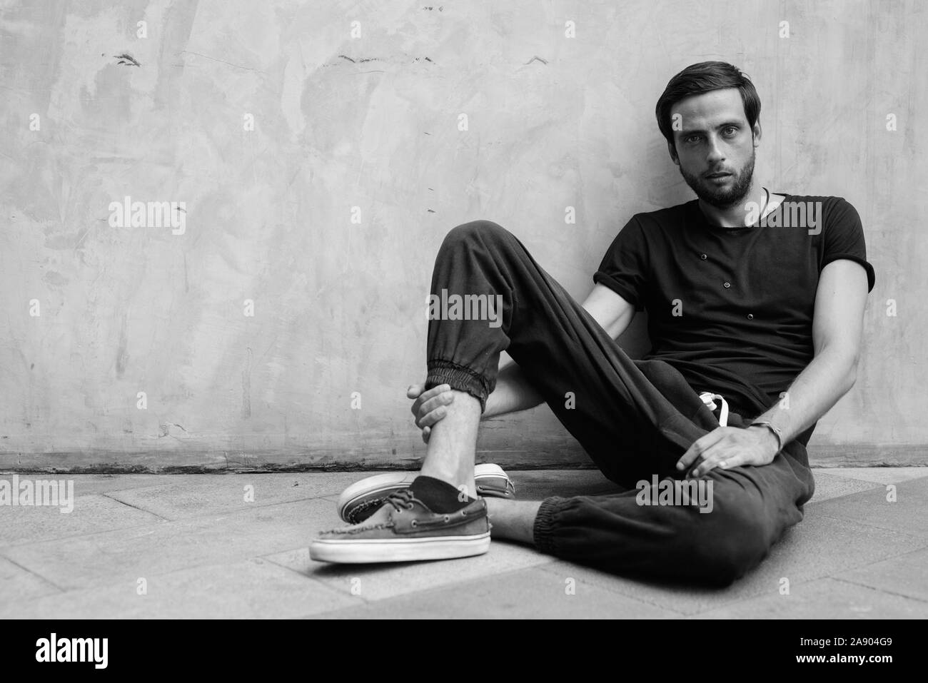Handsome man against concrete wall in the streets outdoors Stock Photo ...
