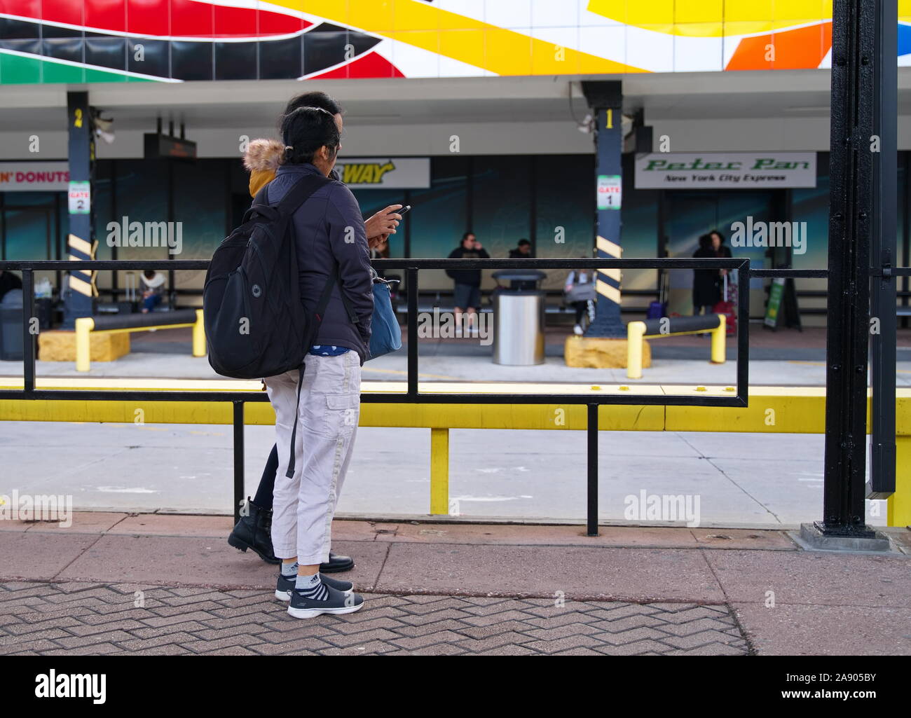 Hartford, CT USA. Oct 2019. Young women at the bus stop checking travel ...