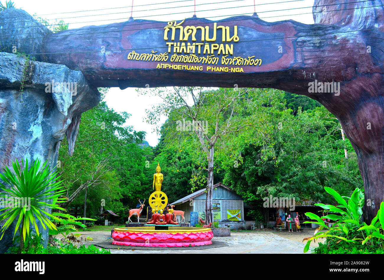 A gold Buddha statue at the entrance to Wat Tham Ta Pan, a hell temple ...