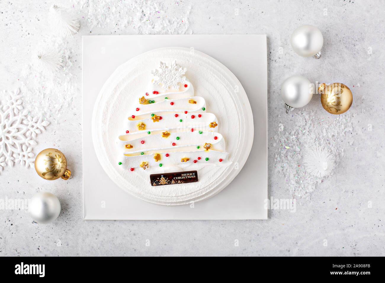 White Christmas cake topped with decorated tree Stock Photo - Alamy