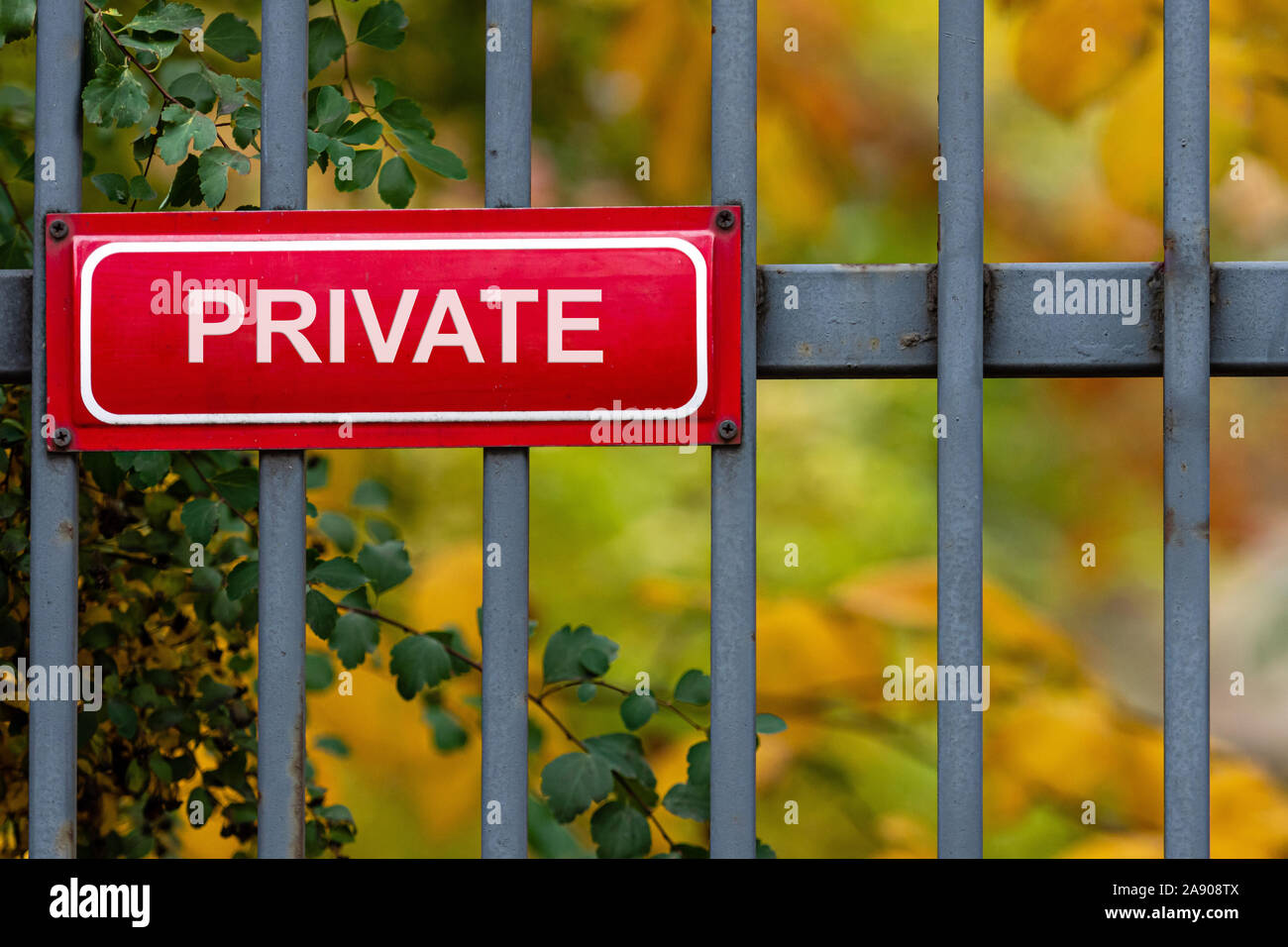 red metal sign with an inscription -PRIVATE on a decorative metal fence ...