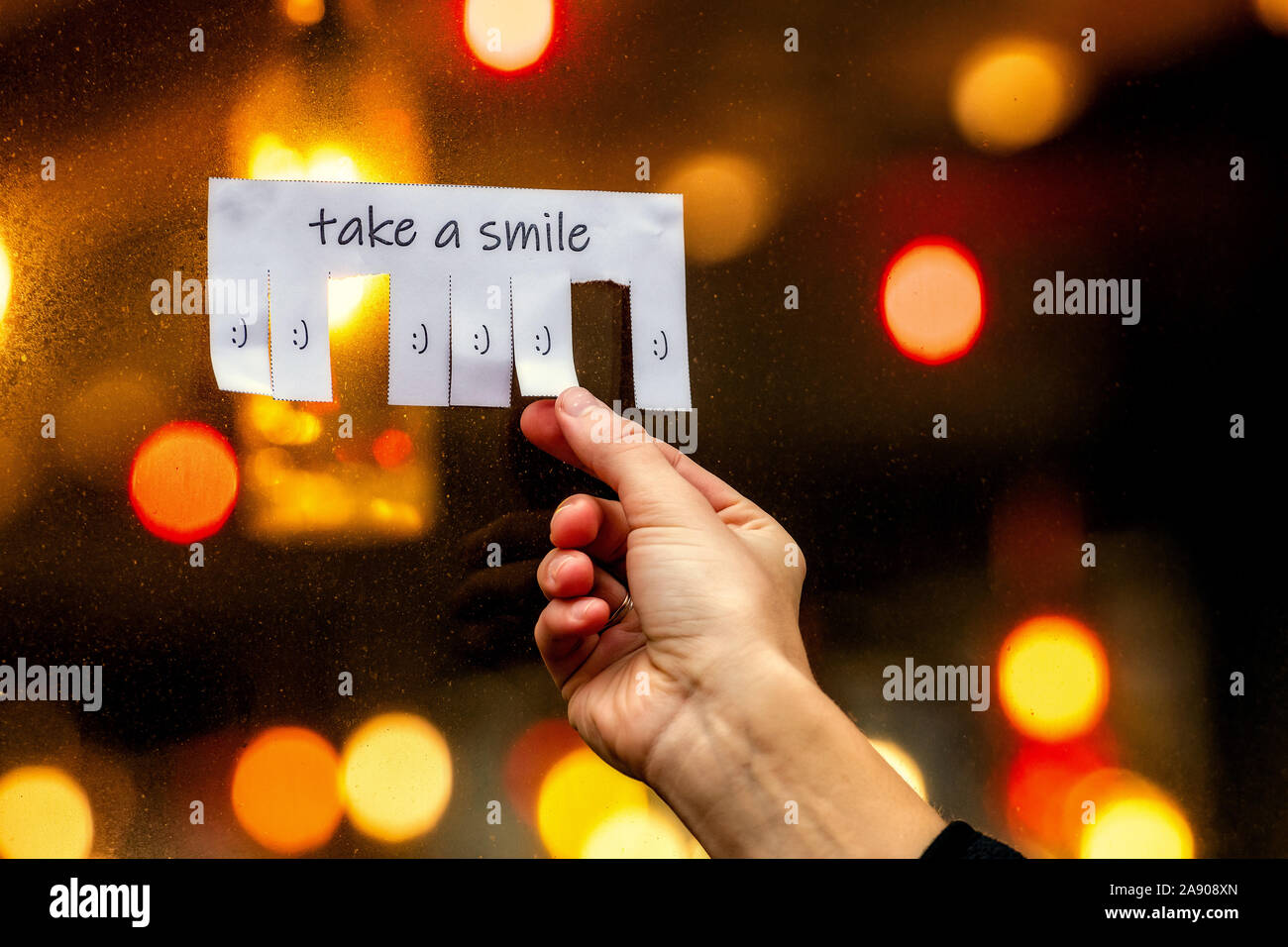 Human hand keeps for paper ad with the phrase: Take A Smile and with a ...