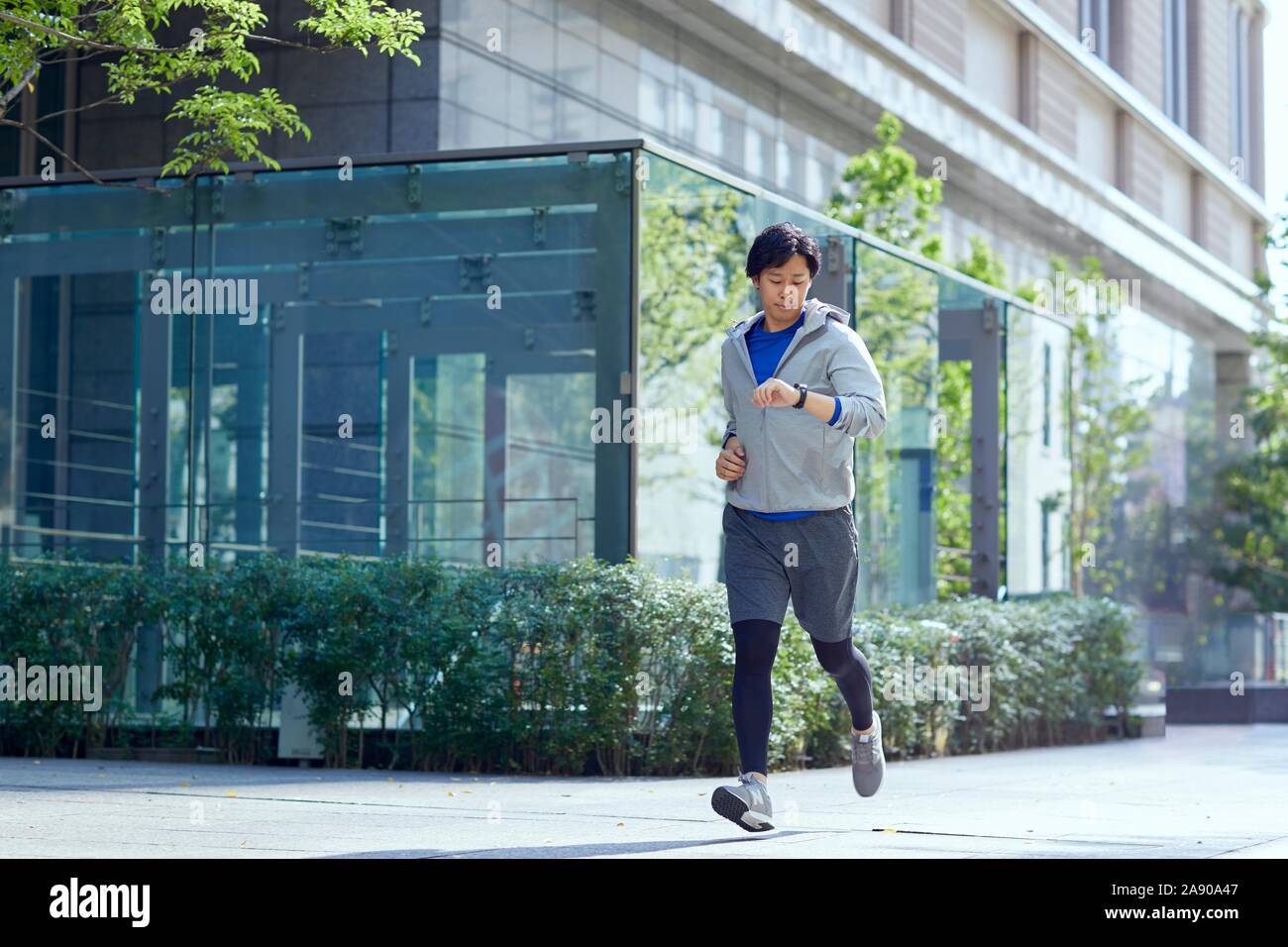 Young Japanese man running downtown Tokyo Stock Photo - Alamy