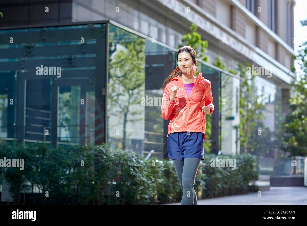 Young Japanese woman running downtown Tokyo Stock Photo - Alamy