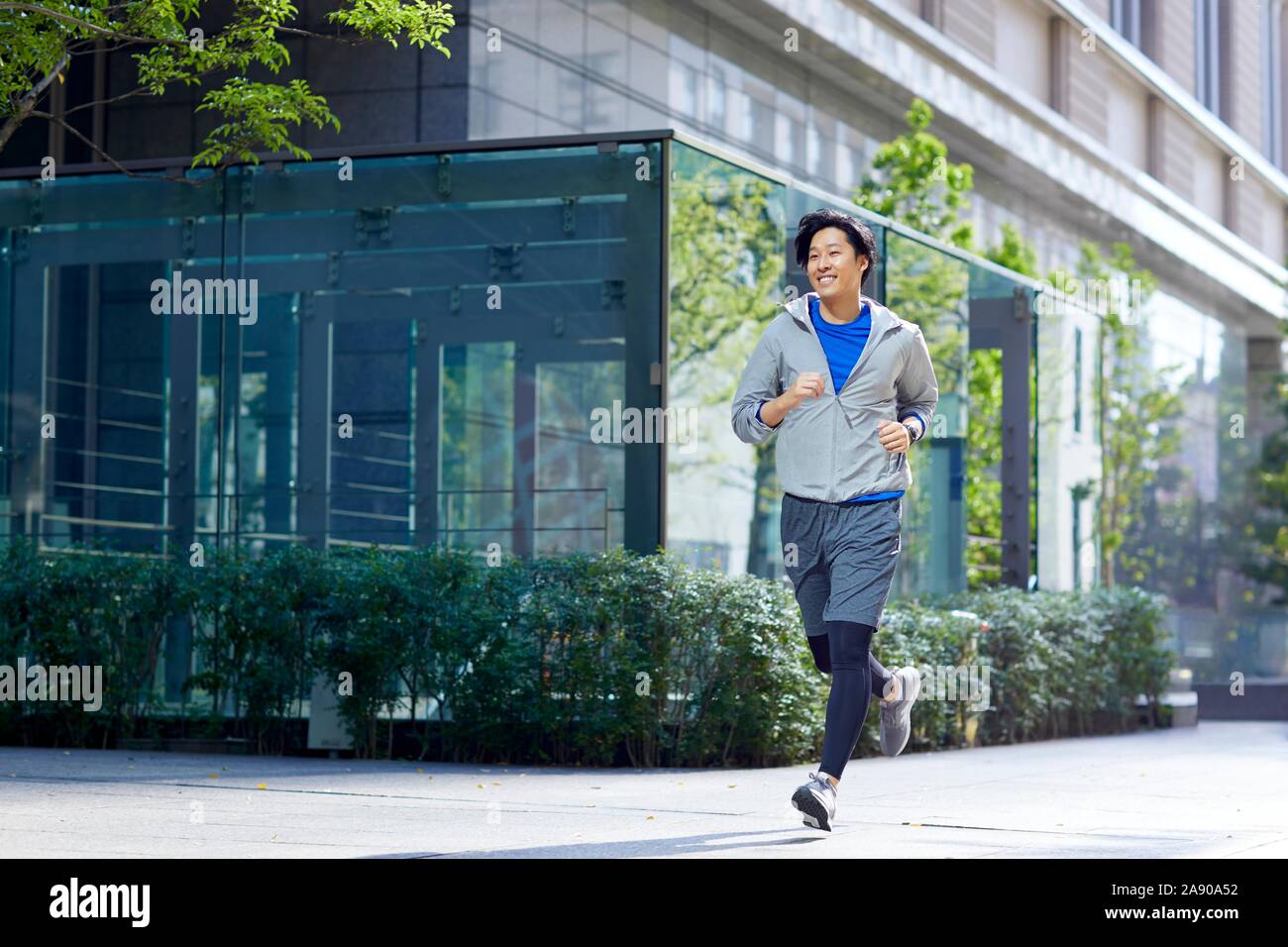 Young Japanese man running downtown Tokyo Stock Photo - Alamy