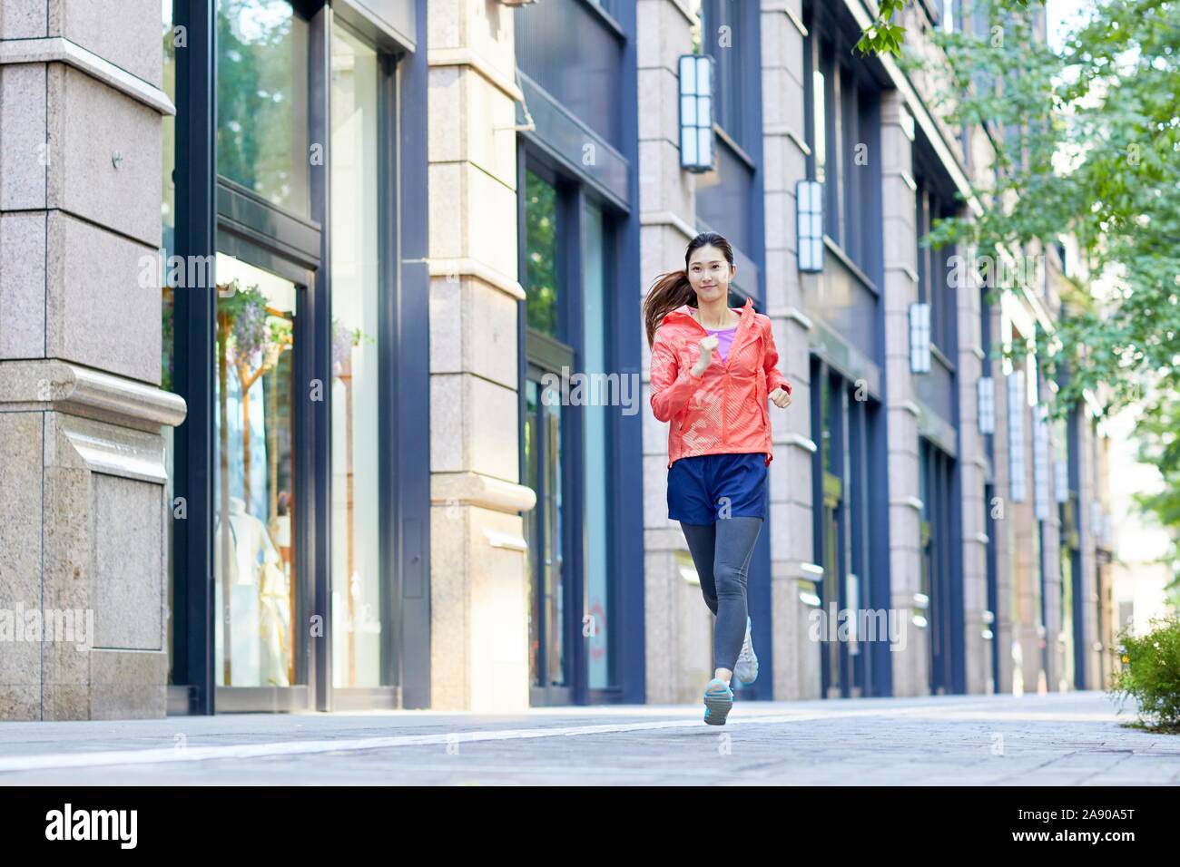 Young Japanese woman running downtown Tokyo Stock Photo - Alamy