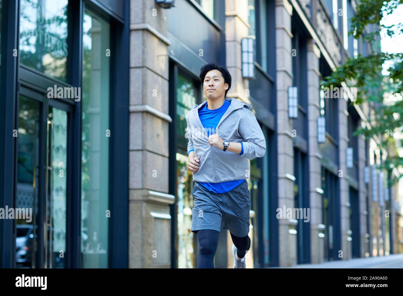 Young Japanese man running downtown Tokyo Stock Photo - Alamy