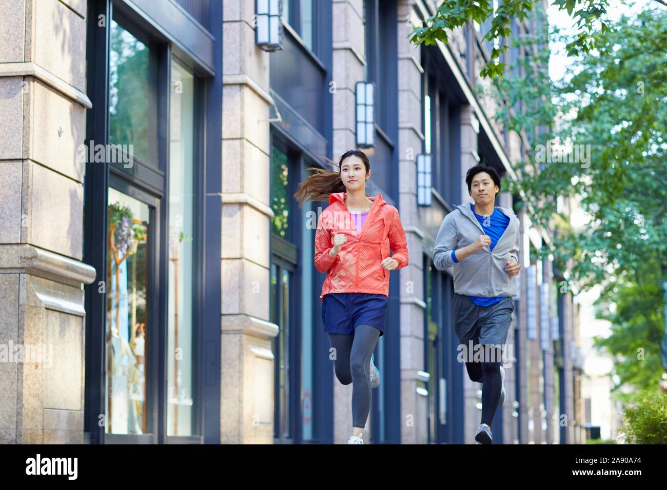 Young Japanese couple running downtown Tokyo Stock Photo - Alamy
