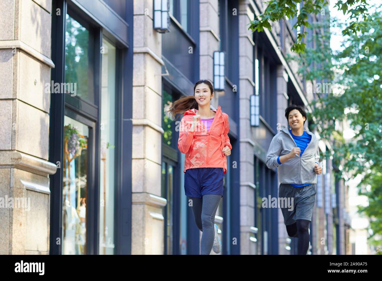 Young Japanese couple running downtown Tokyo Stock Photo - Alamy