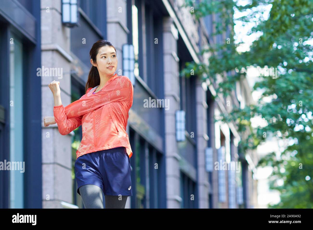 Young Japanese woman running downtown Tokyo Stock Photo - Alamy