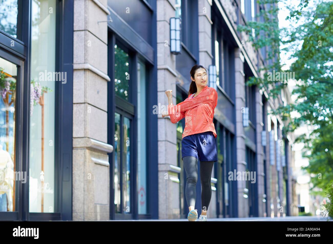 Young Japanese woman running downtown Tokyo Stock Photo - Alamy