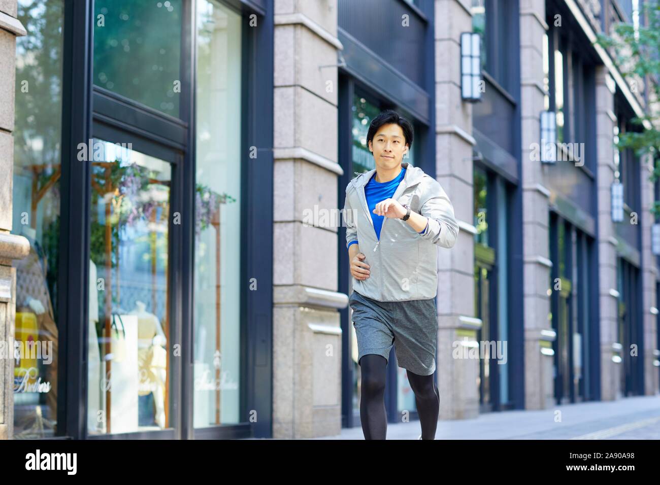 Young Japanese man running downtown Tokyo Stock Photo - Alamy