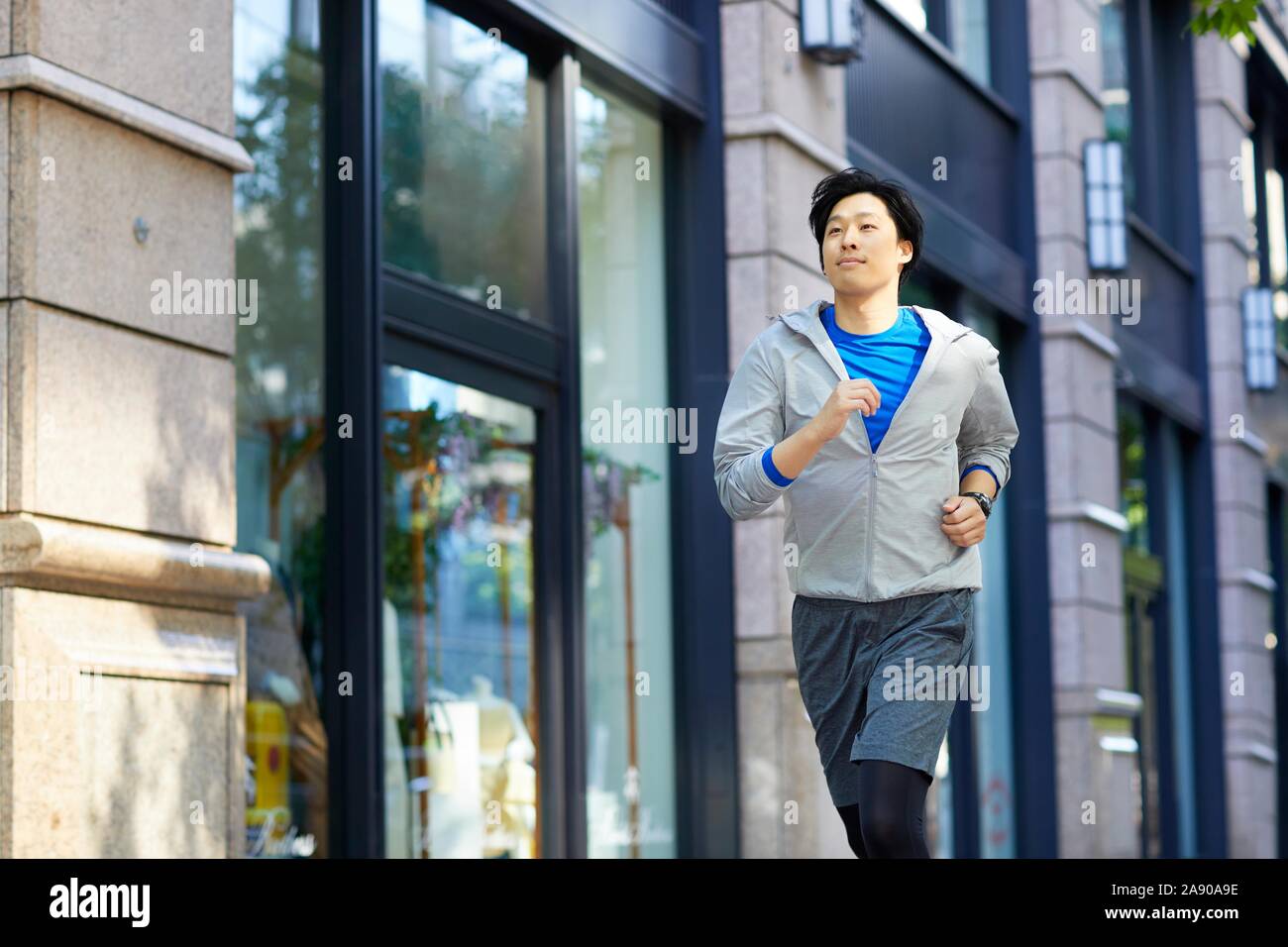 Young Japanese man running downtown Tokyo Stock Photo - Alamy