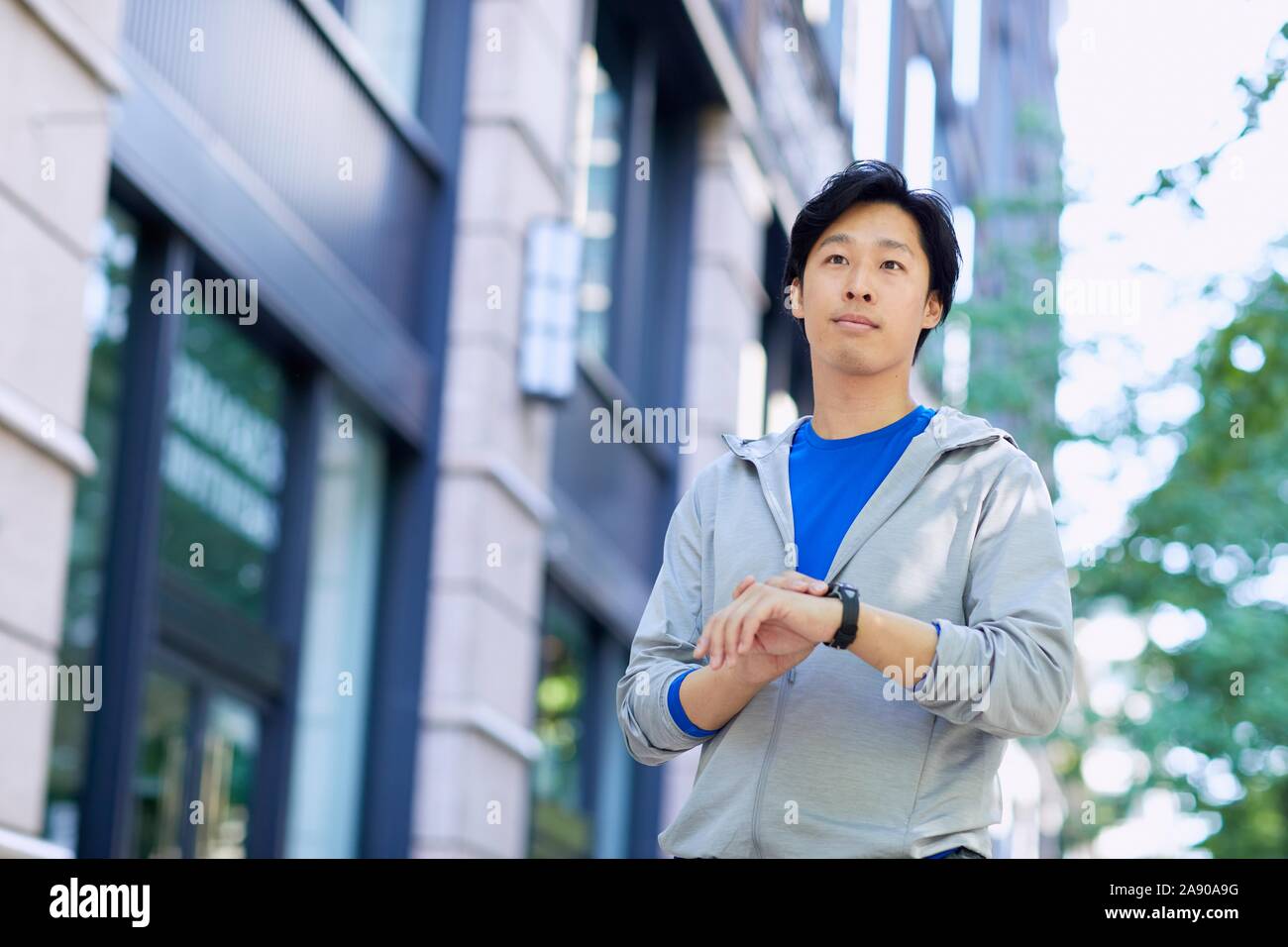 Young Japanese man running downtown Tokyo Stock Photo - Alamy